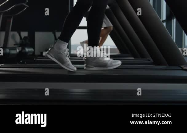 Sporty people jogging on treadmill unknown sportswoman female runner ...