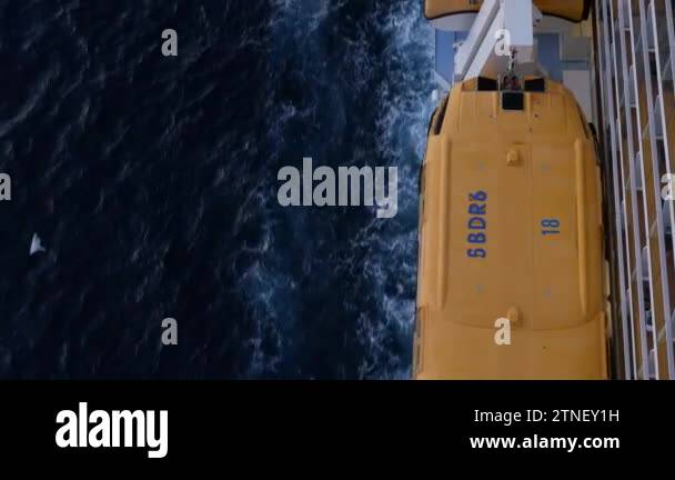Lifeboat on giant cruise ship view down to ocean surface with waves ...