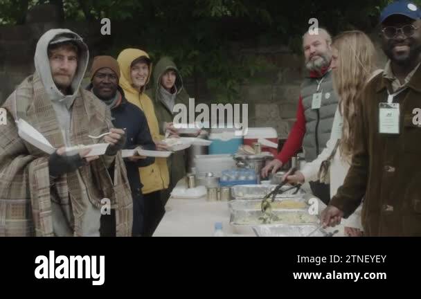 Group portrait of multiethnic homeless people and volunteers smiling ...