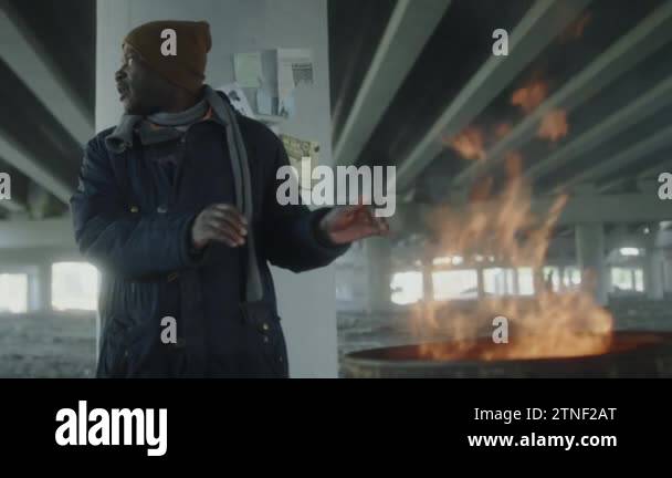 African American homeless man talking with his friend while standing in ...