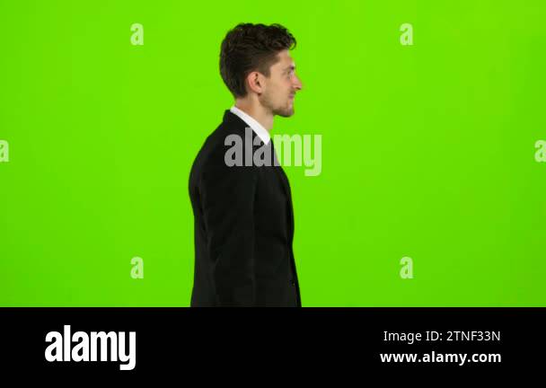 Businessman is going to a meeting and waving greetings. Green screen ...