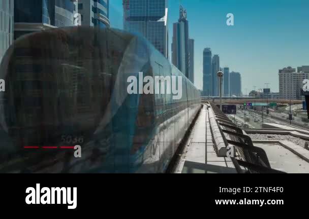 Dubai metro train move away along elevated railway, telephoto view back ...