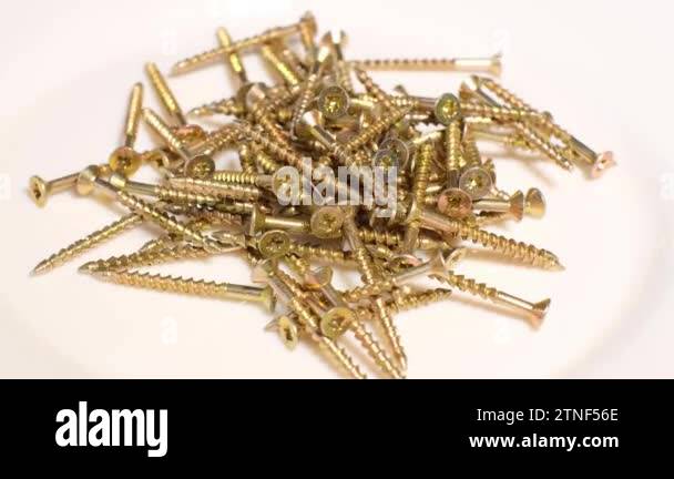 Yellow metal screws rotate in a circle. Fasteners when working with ...