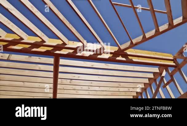 Wood frame truss roofing is constructed at new house construction site ...