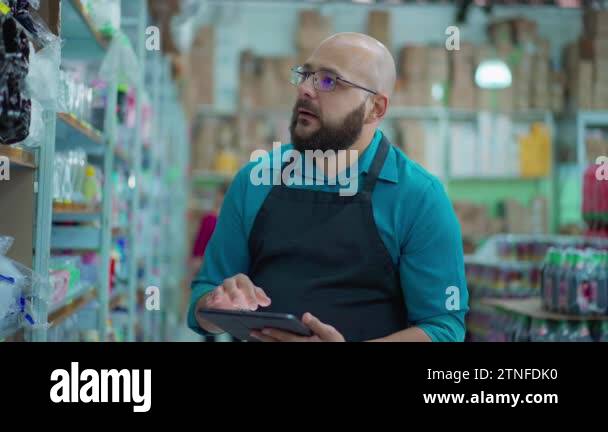 Grocery Store Employee Inspecting Products Using Tablet in Aisle ...