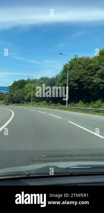 Vertical video, car dashboard view driving exiting Manchester's ring road M60 at J11 and joining ...