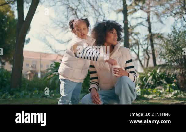 Cute child throwing crumbs to birds standing in green park with caring ...