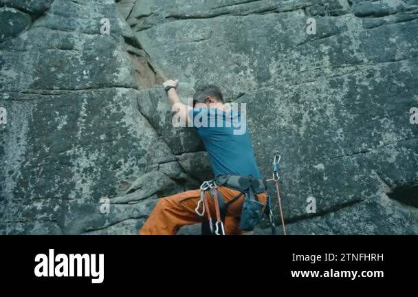 strong man rockclimber climbing on tough sport route, searching ...