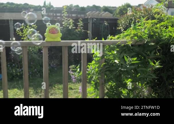 Hot Sunny Day outside the garden. blowing and catch spray bubbles with ...