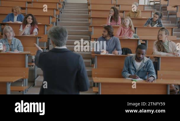 Experienced professor talking to group of students answering questions ...