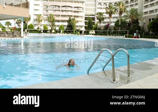 Sexy girl in bikini comes out of the pool. Young woman in a swimsuit ...
