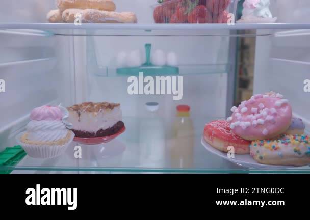 Refrigerator shelves with unhealthy food, inside view. The door of the ...