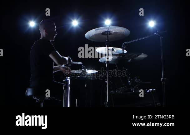 Musician plays professionally music on drums. Black background. Side ...