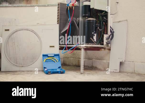 Revealing handheld camera shot of broken outdoor air cooling unit in ...