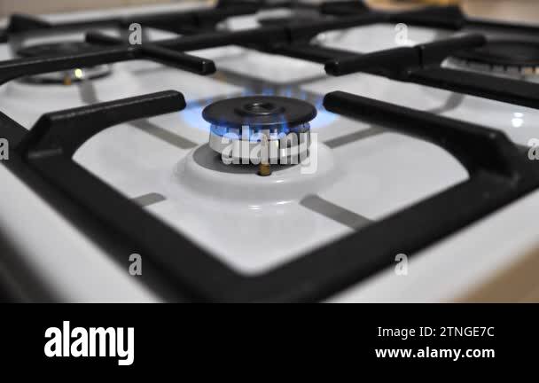Turning on and off hob of gas stove. Close-up of flame during operation ...