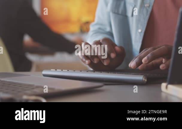 Unrecognizable video game developer typing on wireless keyboard while ...