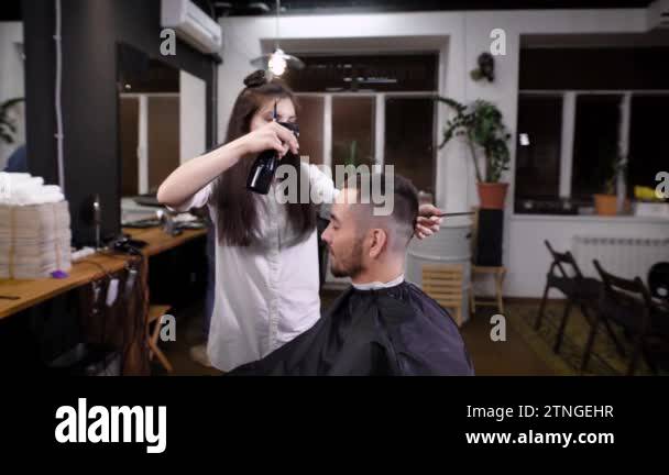 Man hipster visiting barber shop. Woman barber making stylish haircut ...