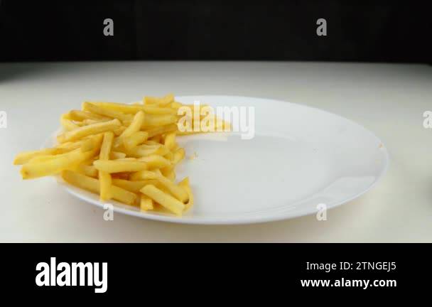 Hamburger down on fried potato chips falling, slow motion, fast food ...