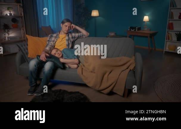 A married couple fell asleep while watching TV late at night. A man ...