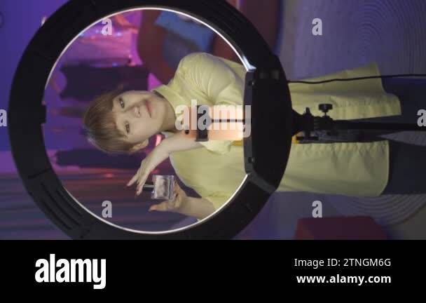 Beautiful female blogger showing a bottle of perfume and filming a ...