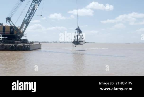 Bucket dredge mounted on a barge remove sediment from one part of a ...