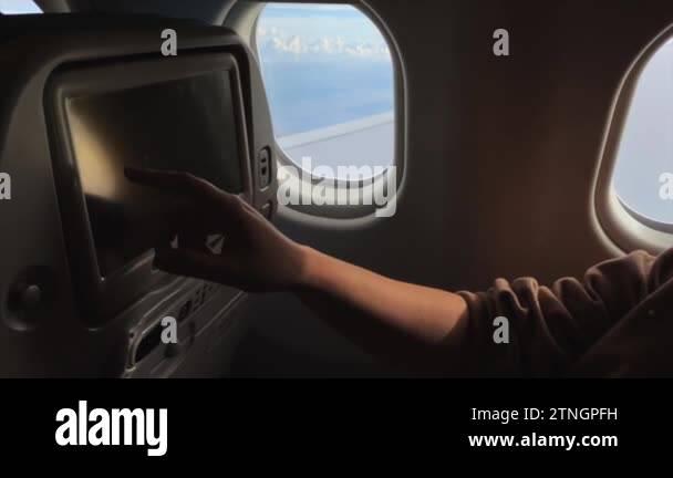 inside modern and comfortable plane cabin, passenger is using built-in ...