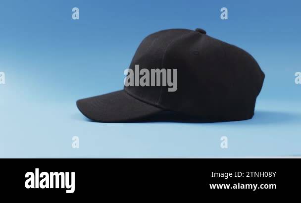Video of black baseball cap and copy space on blue background. Headgear ...