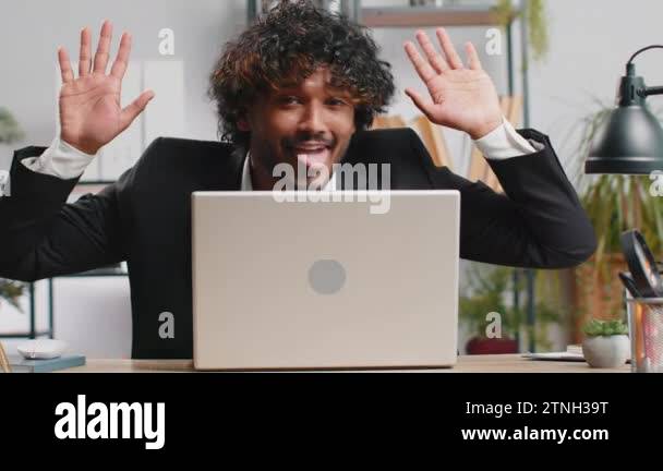 Indian businessman hiding behind laptop computer, making funny face ...