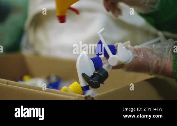 Close-up female hands placing plastic dispenser pumps in box on ...