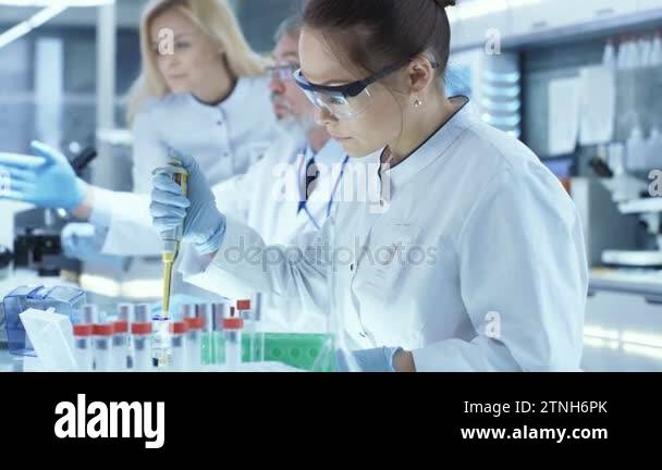 Team of Research Scientists Working With Personal Computer, Analysing ...