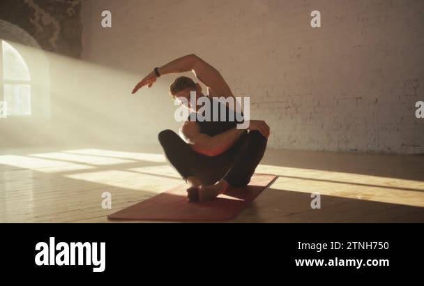 A male athlete in a black sports summer uniform does exercises to ...