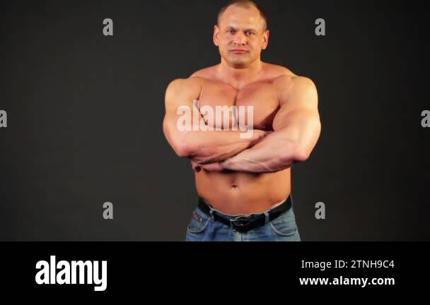 Bodybuilder in jeans shows his muscular body lit Stock Video Footage ...
