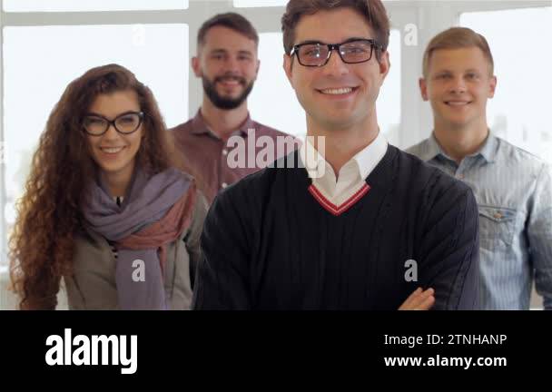 Three young men and one woman posing at the office. Brunette man in ...