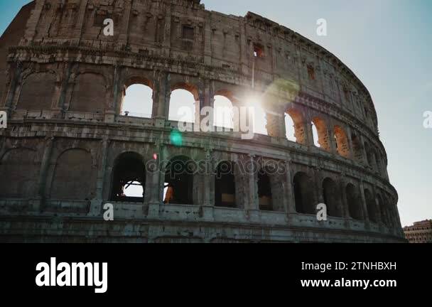 The sun shines beautifully through the arches of the Colosseum in Rome ...
