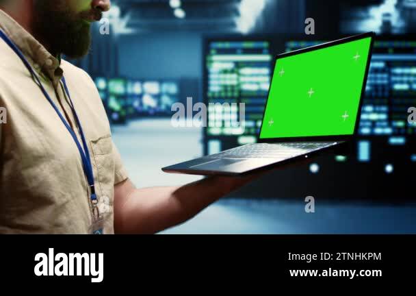 Specialist using green screen laptop to check server clusters configuration settings, close up ...