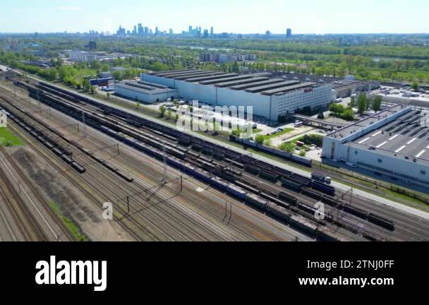 Flying above industrial railroad station with cargo trains and freight ...