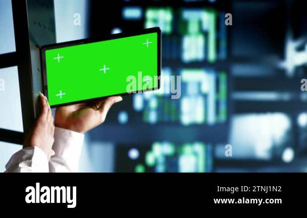 Vertical video Specialist using green screen tablet to check server rigs doing intense ...