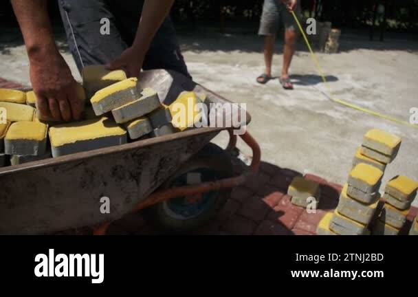Construction Site, the Construction Worker Unloads the Stone Paving ...