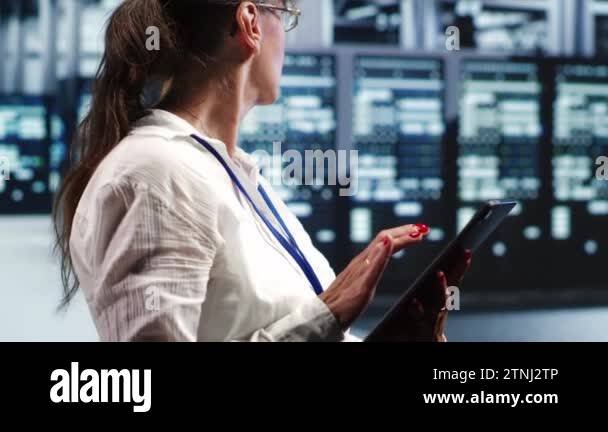 Aged technician working in data center housing GPU dedicated blade servers that can process ...