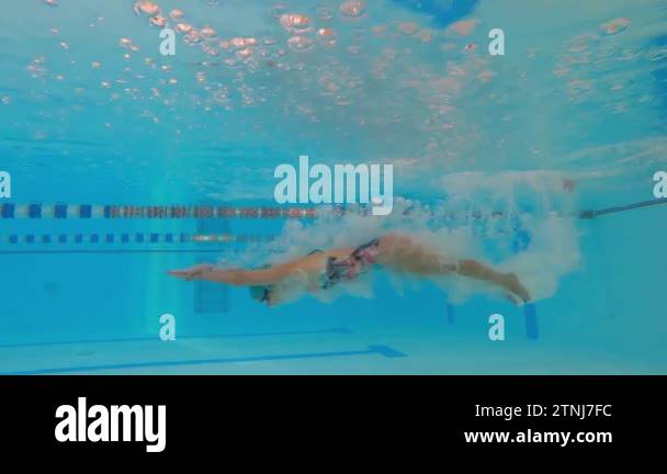 Woman athlete swims underwater in the pool. Slow motion of a female ...