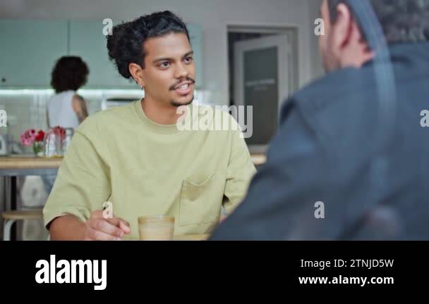 Two male friends talking in small quiet cafe close up. Young ...
