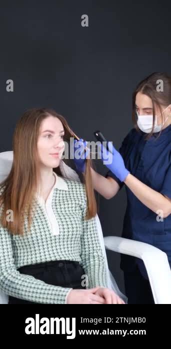 Consultation of a trichologist. The doctor takes pictures, scans the ...