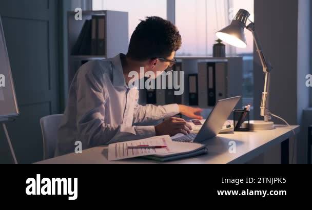Attentive businessman sits at his desk, fully engrossed in his work ...