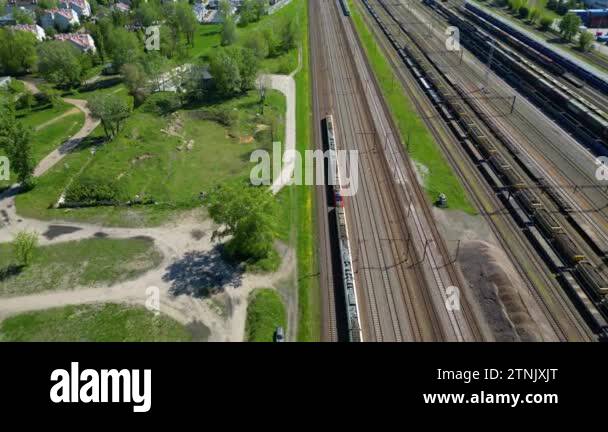 Flying above industrial railroad station with cargo trains and freight ...