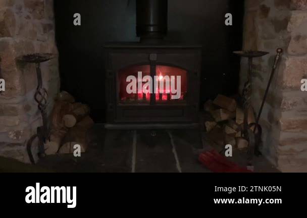 Close up of a roaring and bright orange log fire in a cast iron wood ...