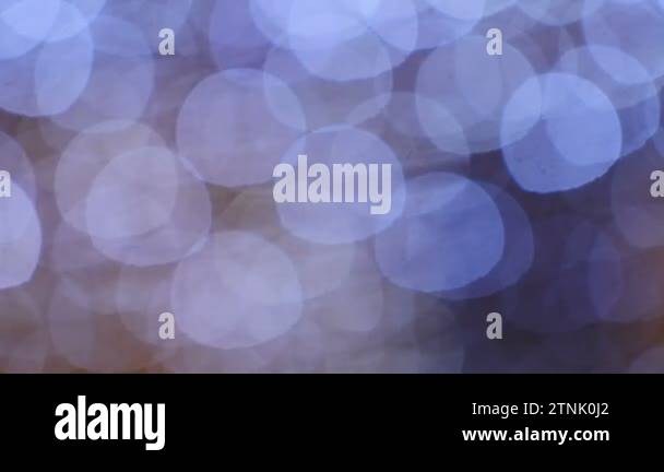 Slow motion blurred blue light spots brightly shine in darkness and ...