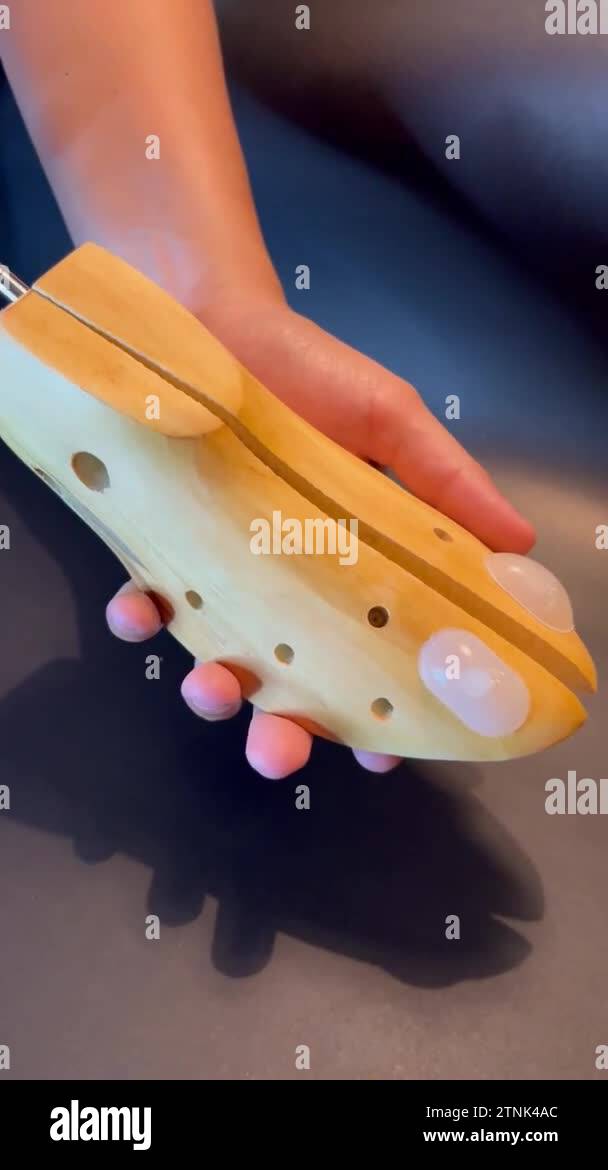 Skilled hands use shoe stretcher, highlighting features and size ...