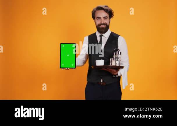 Staff member presents tablet with greenscreen in studio, holding phone ...