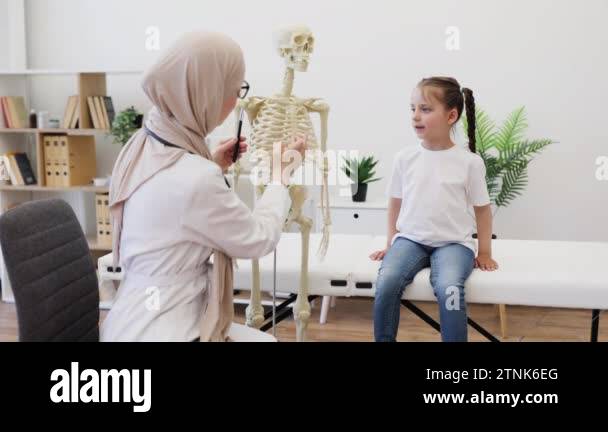 Close up view of tween caucasian girl pointing at ribs on skeleton ...