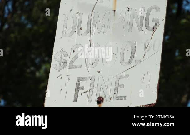 old worn and faded dumping $2000 fine sign with light black writing on ...